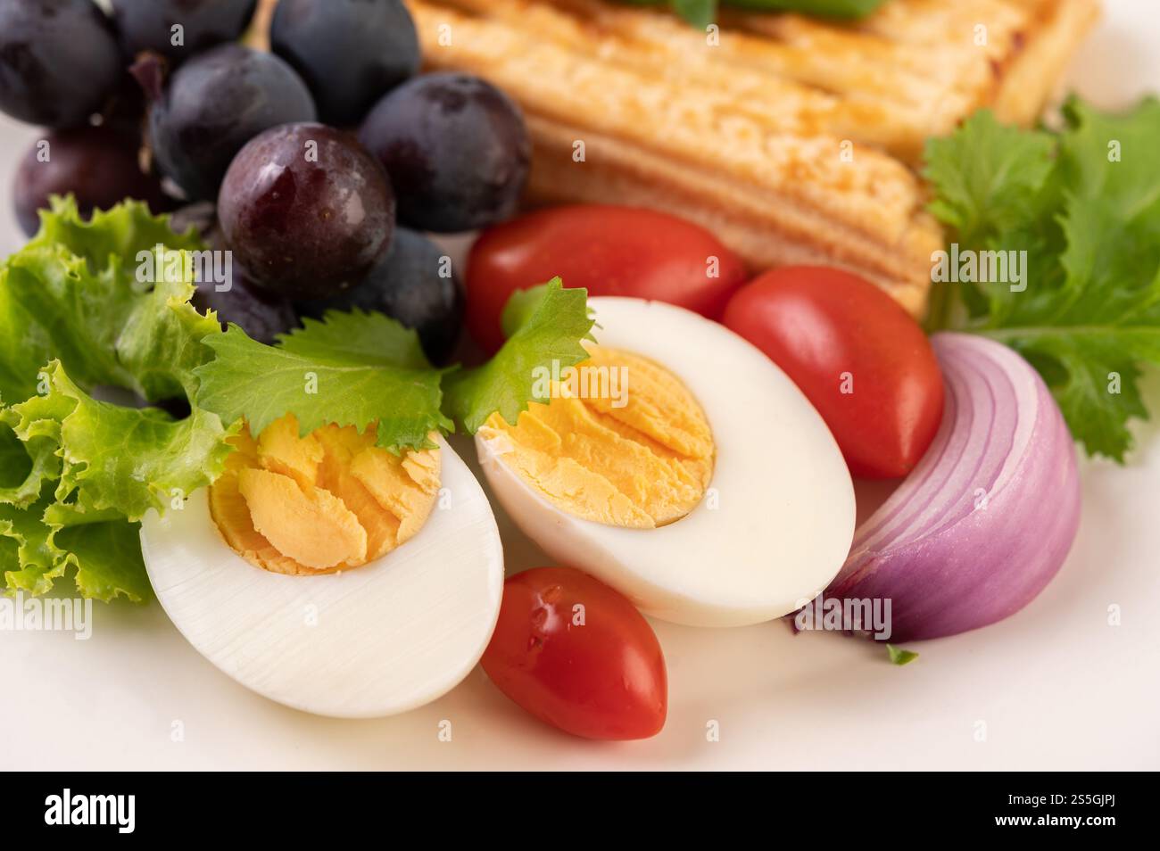 Breakfast consists of bread, boiled eggs, black grape salad dressing ...