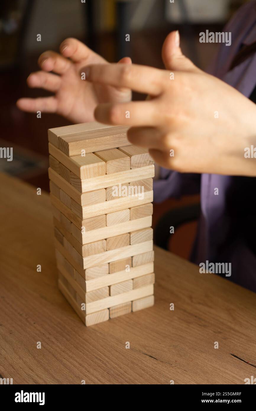 Building Team Skills Wooden block tower with hands in action symbolizes ...