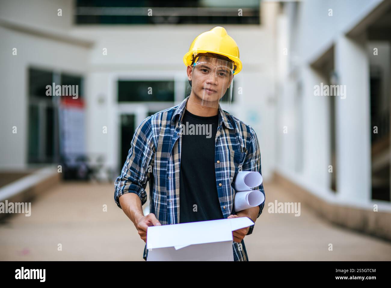 Architects hold the building plan and check the work Stock Photo - Alamy