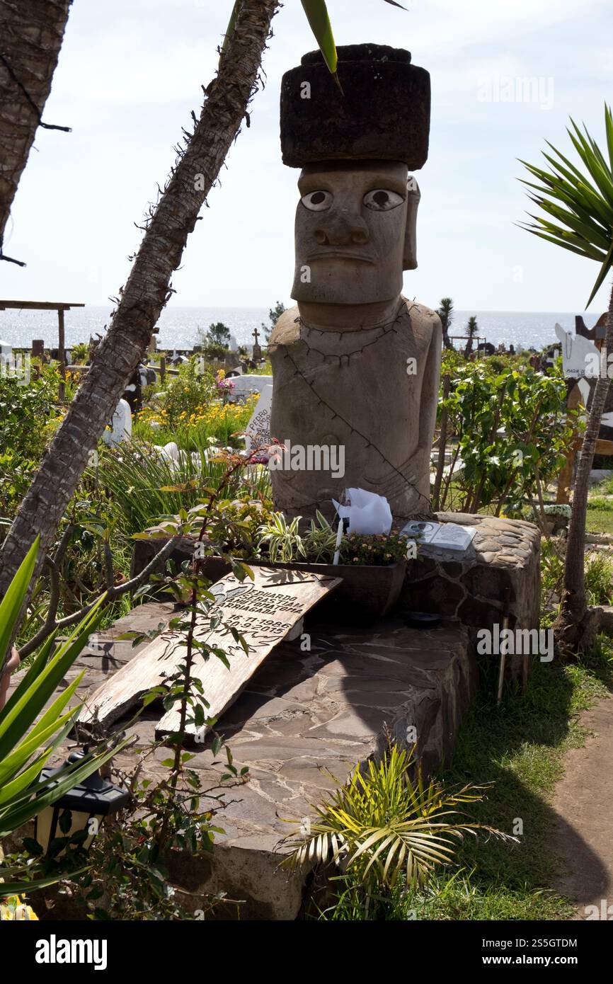 A Moai on a grave in the Hanga Roa cemetery display Christian and ...
