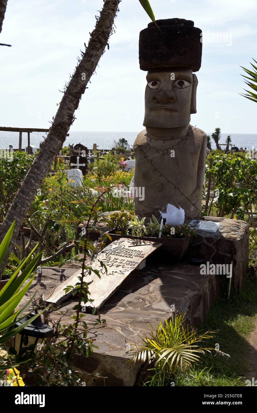 A Moai on a grave in the Hanga Roa cemetery display Christian and ...