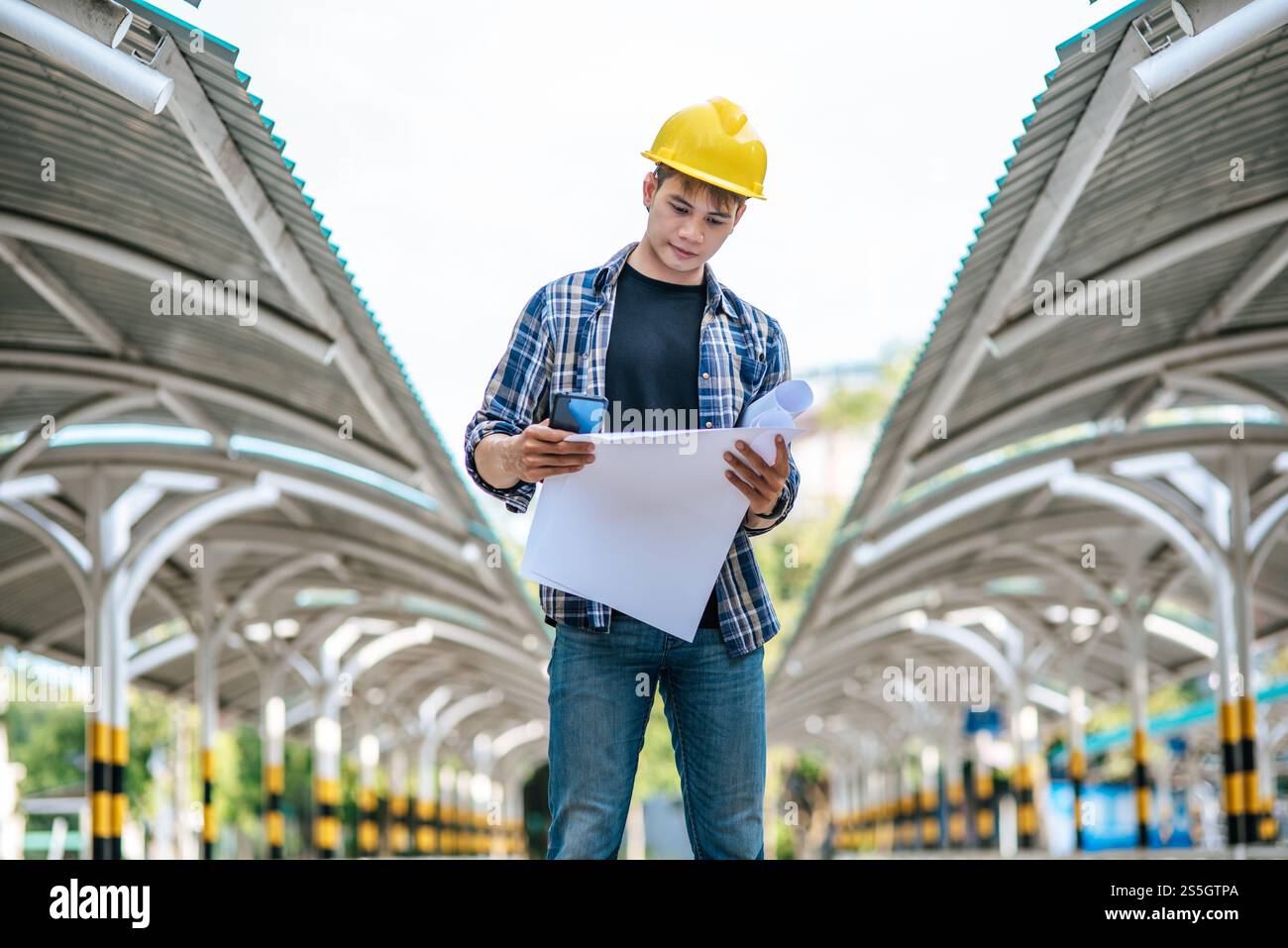 Architects hold the building plan and check the work Stock Photo - Alamy