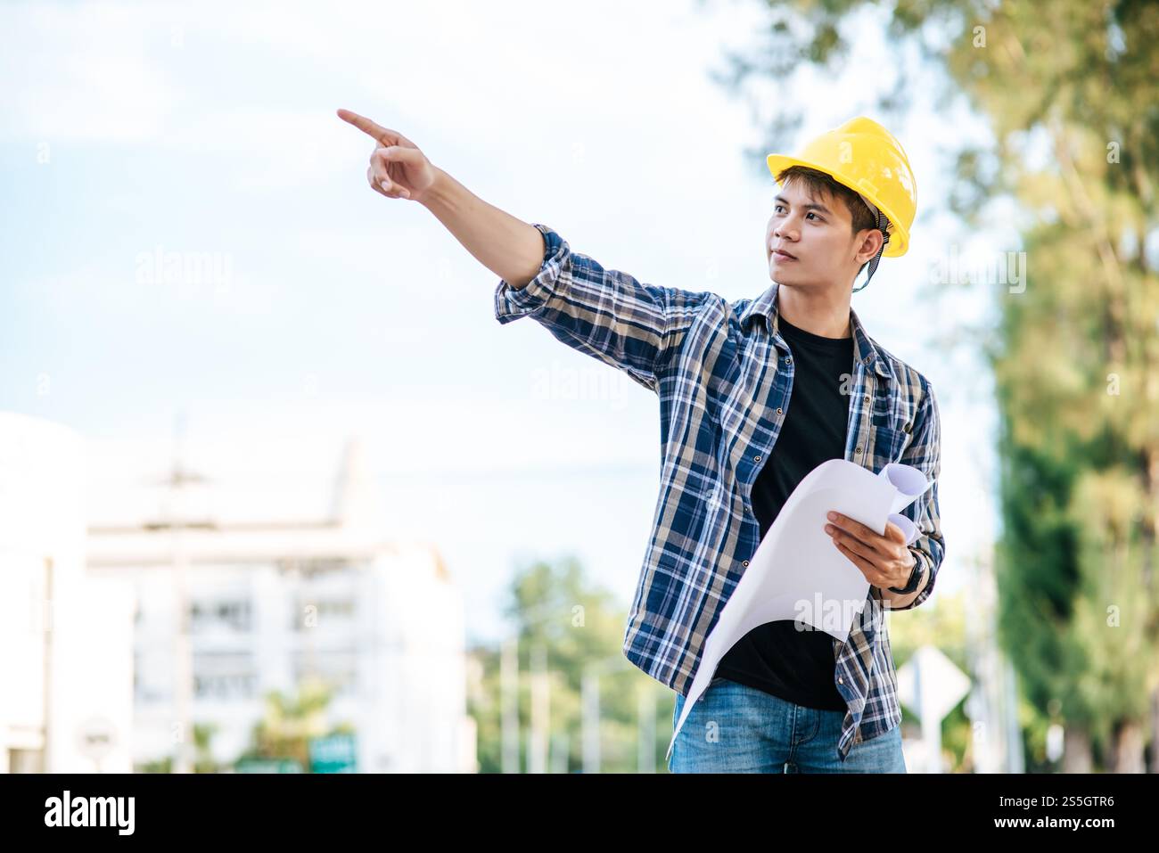 Architects hold the building plan and check the work Stock Photo - Alamy