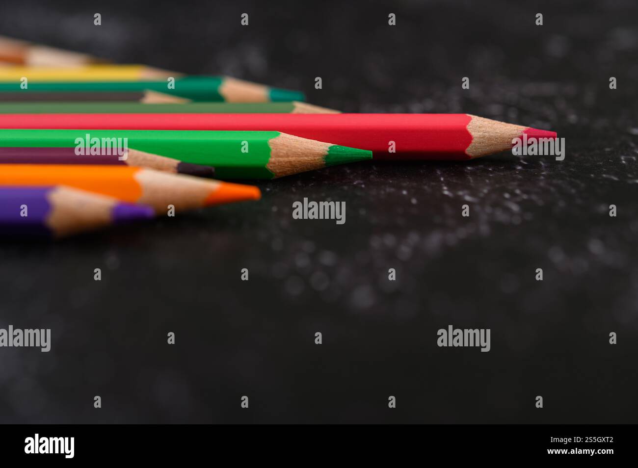 colorful crayon pencils with triangle shape on black background with ...