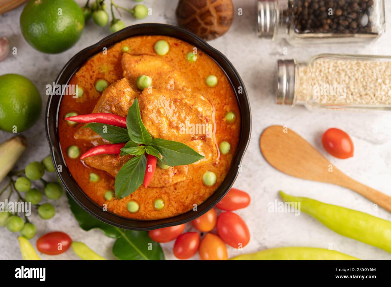 Chicken red curry in a black bowl, chilli, tomato, galangal, shiitake ...