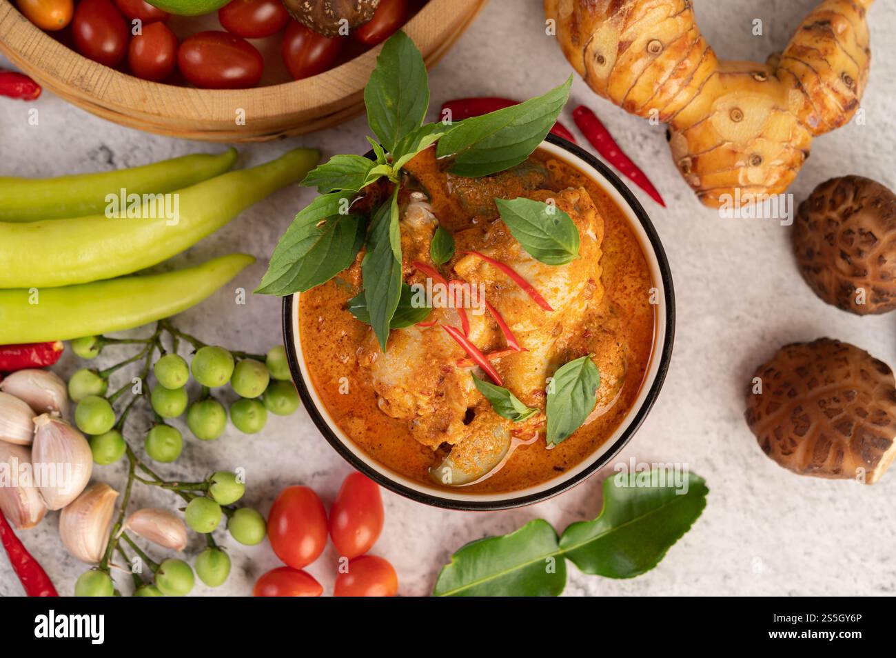 Chicken red curry in a black bowl, chilli, tomato, galangal, shiitake ...
