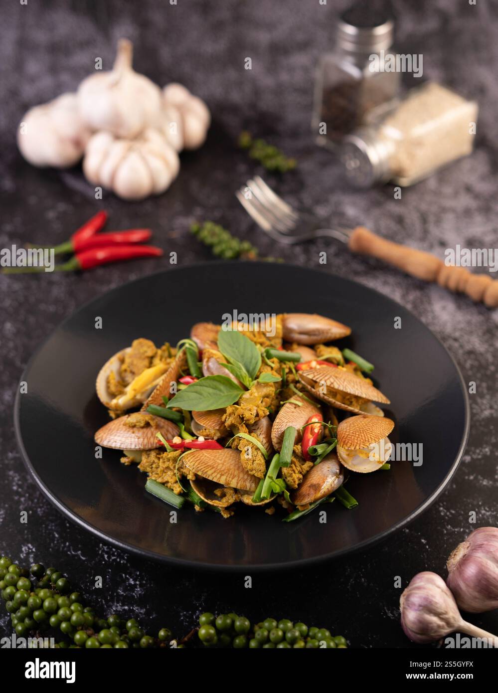 Curry powder stir fry on a black plate along with garlic. Chili and ...