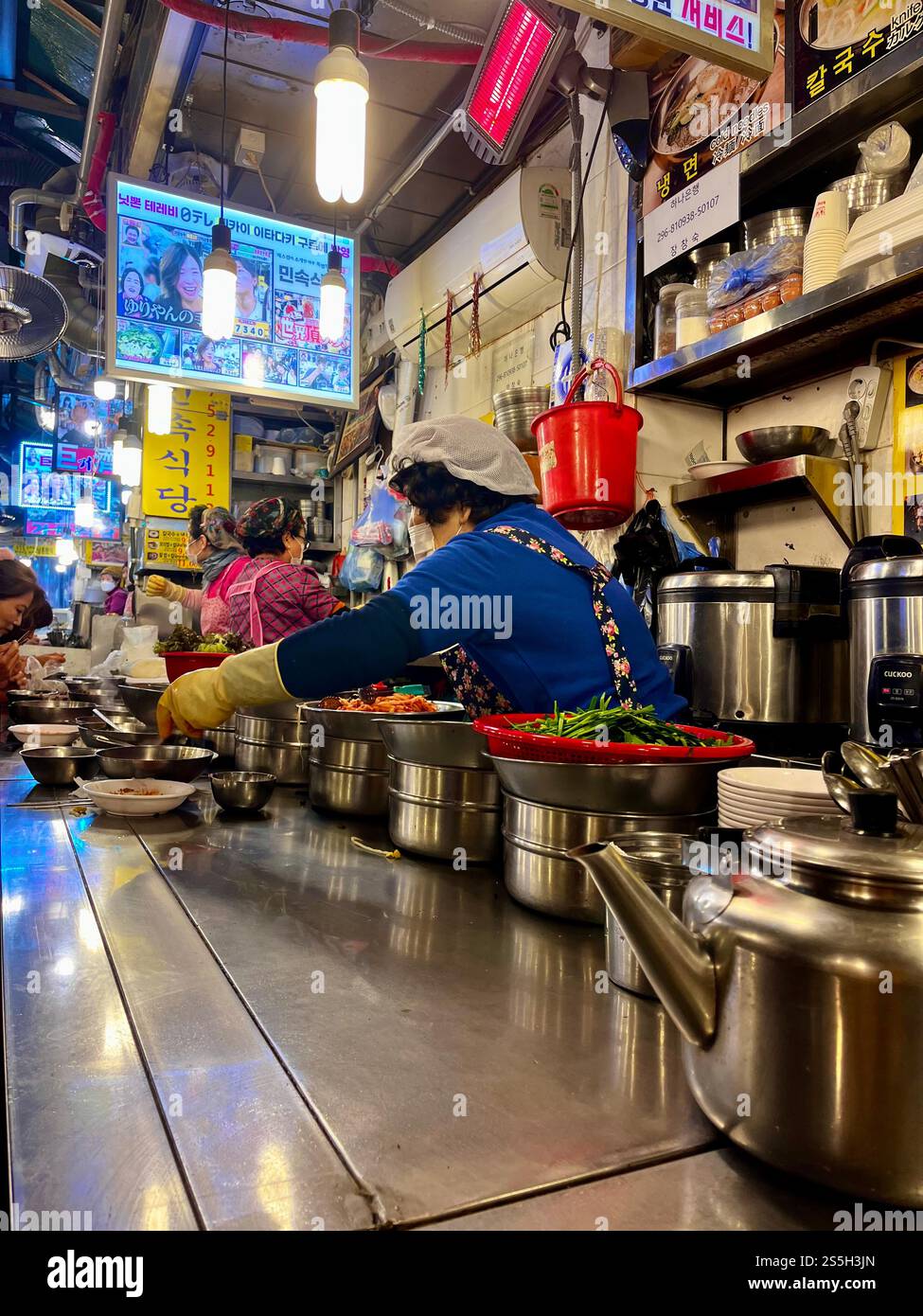 Street food vendor cooking Korean food at a market stall in Kalguksu ...