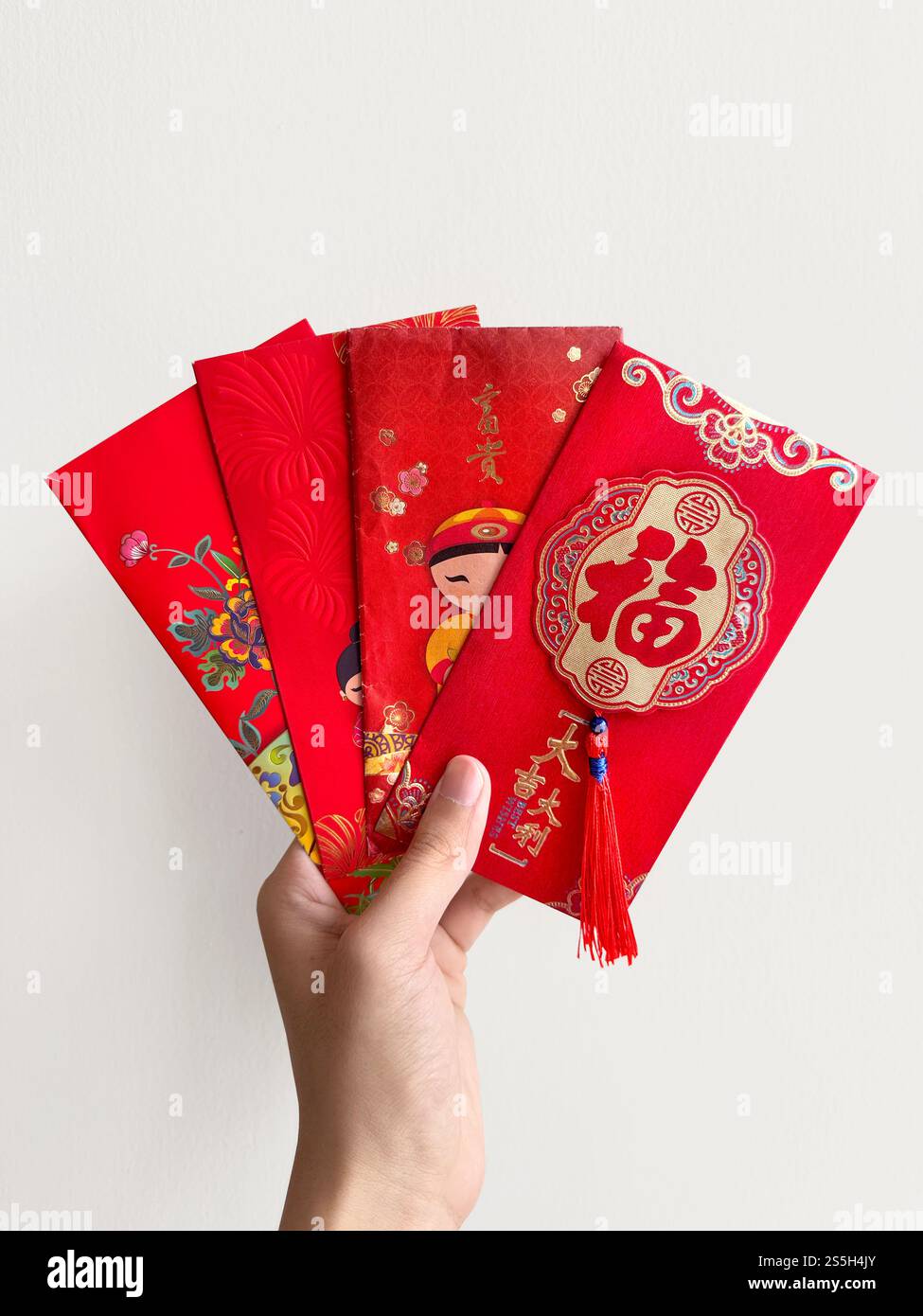 Hand holding Chinese red envelope, also known as hongbao or angpao ...