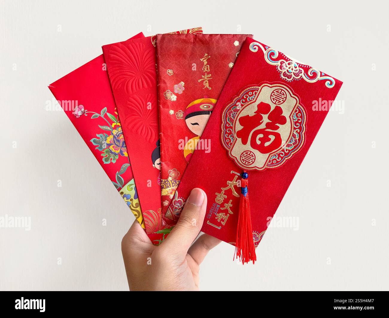 Hand holding Chinese red envelope, also known as hongbao or angpao ...