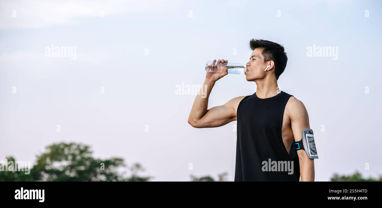 Men stand to drink water after exercise. Selective focus Stock Photo ...