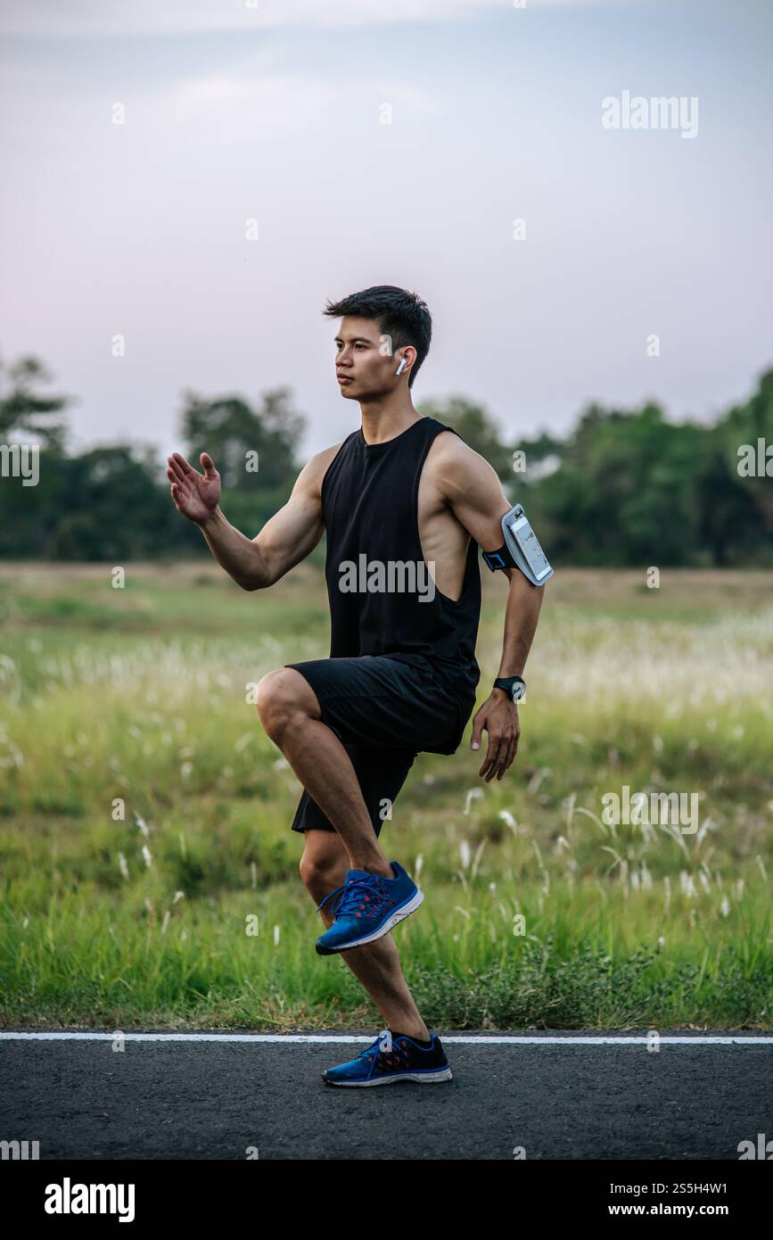 Men exercise by running and lifting their knees forward Stock Photo - Alamy