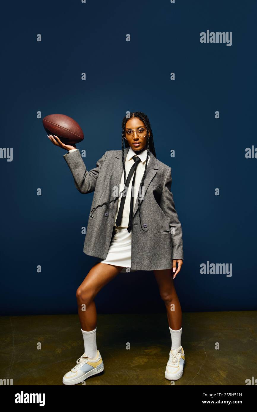 A beautiful young woman stands with power and poise, dress in a stylish ...