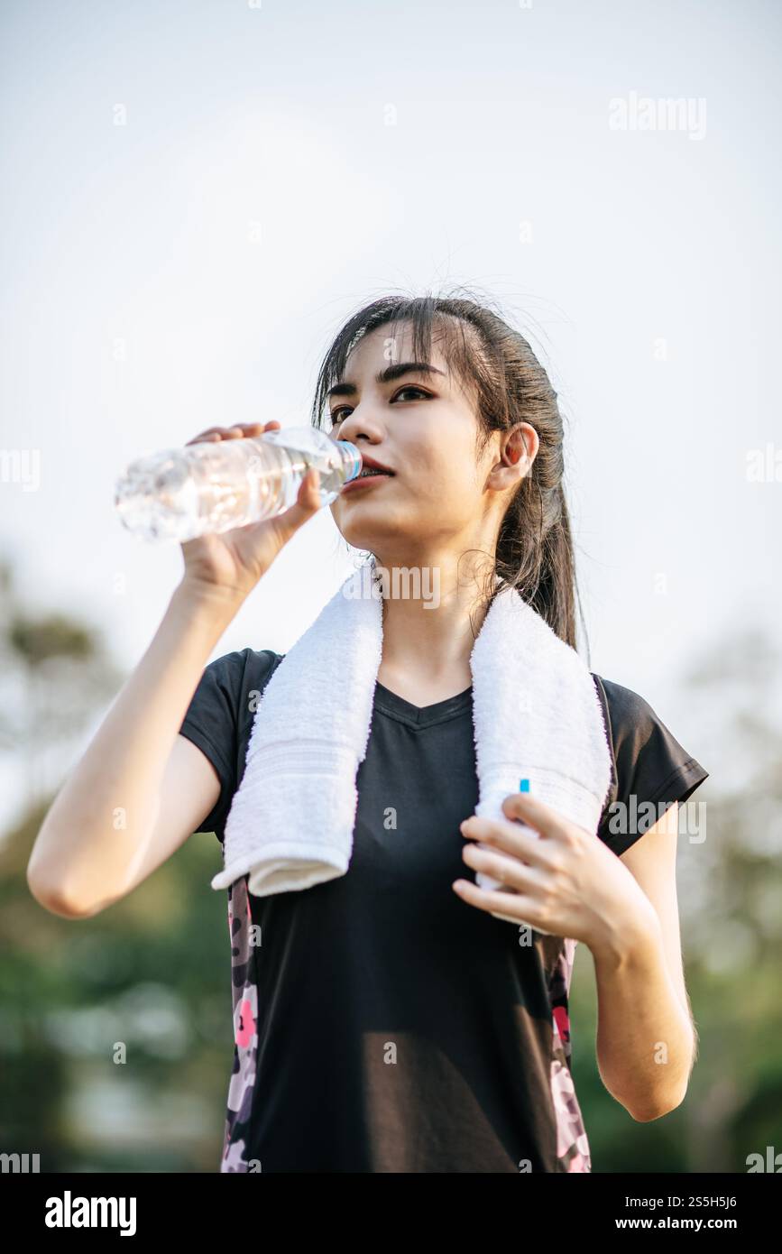 Women stand to drink water after exercise. Selective focus Stock Photo ...
