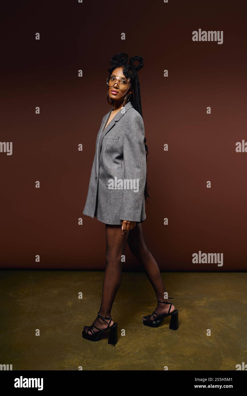 A young woman stands poised in an oversized blazer, exuding elegance ...