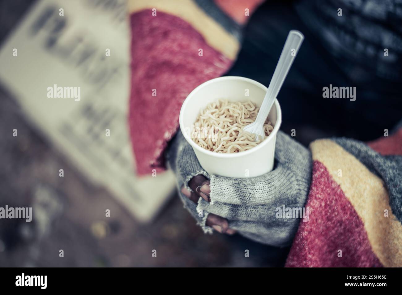 The beggars sat wrapped in cloths and eating noodles Stock Photo - Alamy