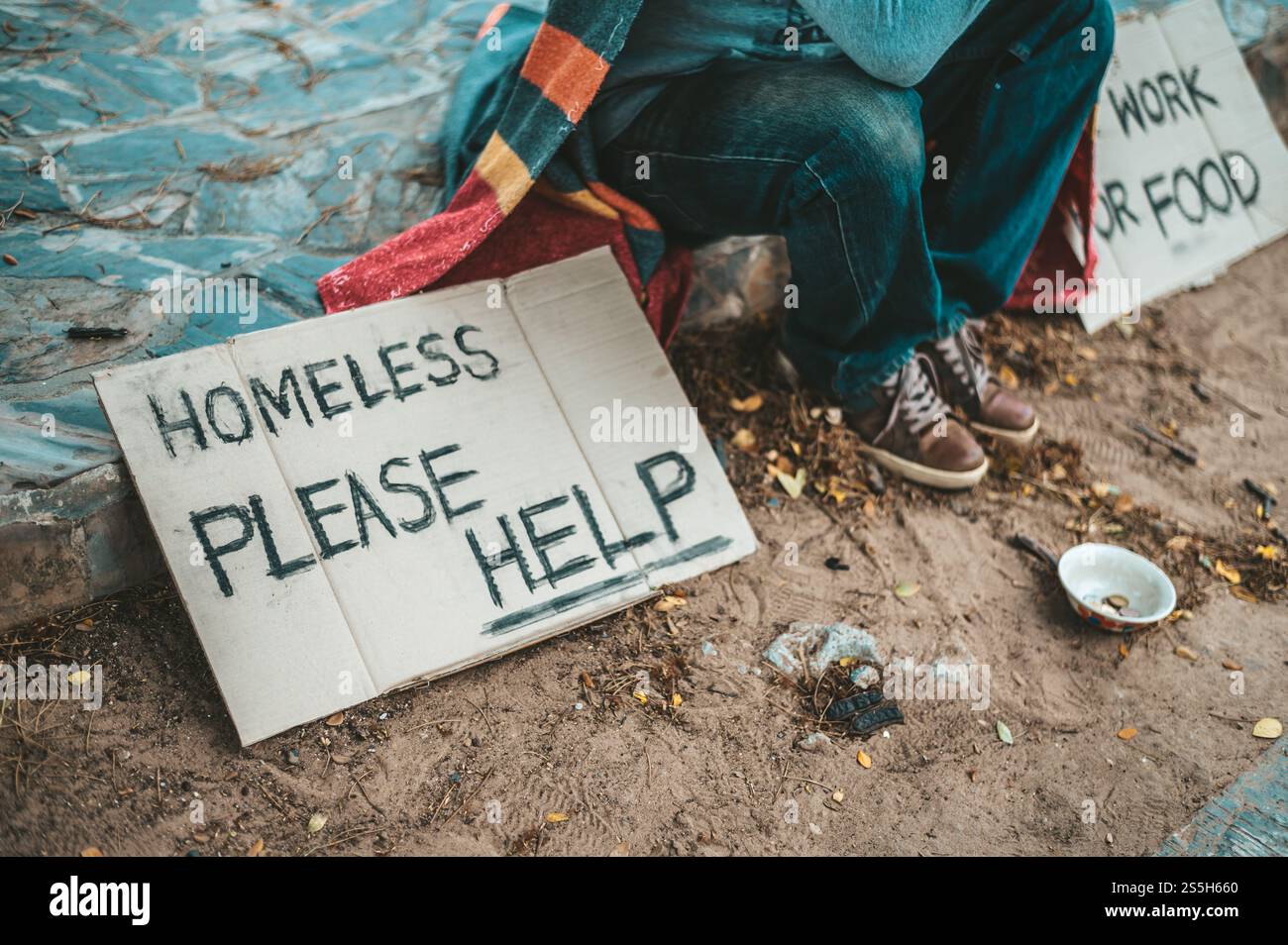 a man sitting beggars with homeless please help message. Selective ...