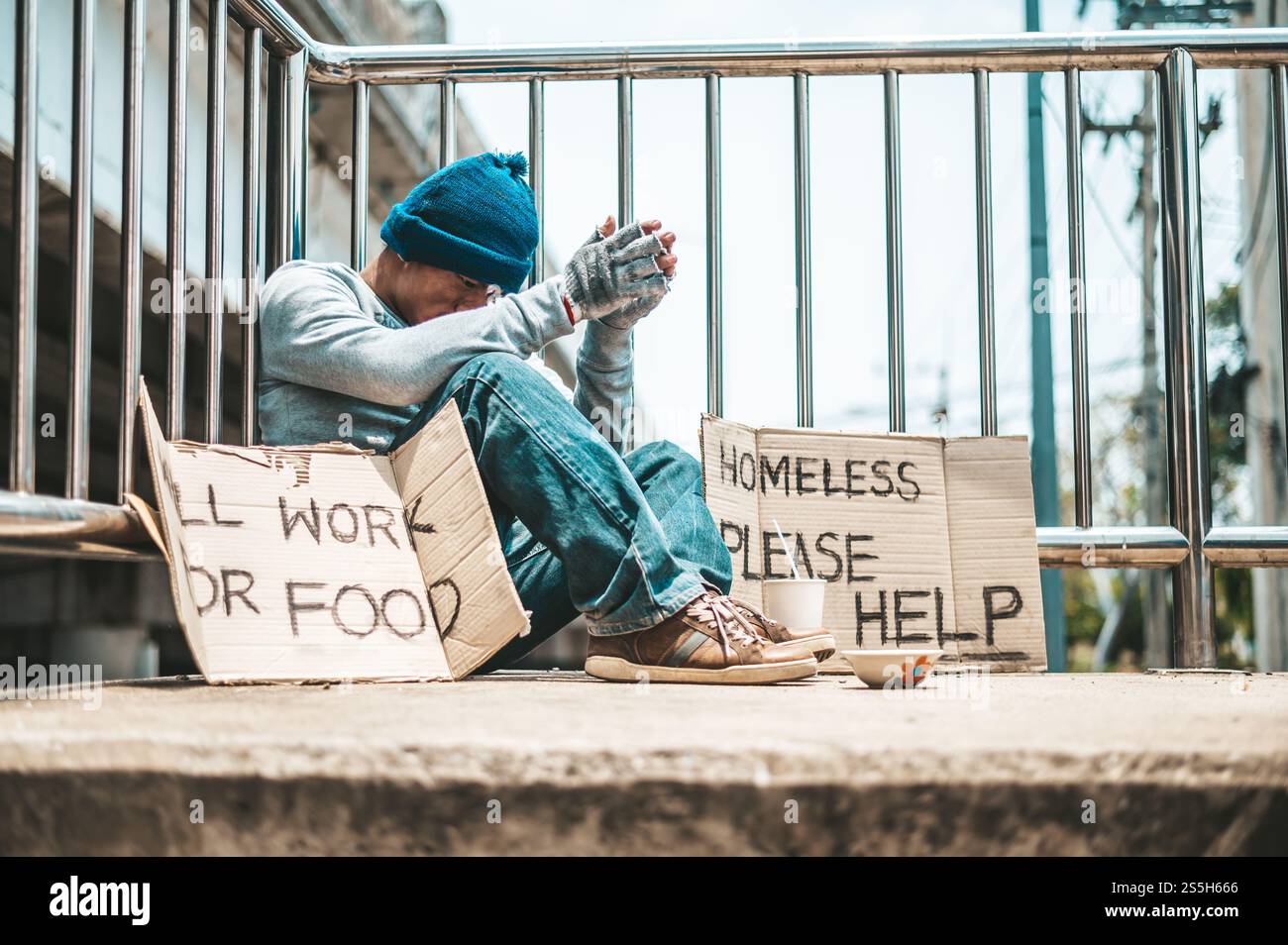 The man sitting begging on an overpass with messages homeless people ...