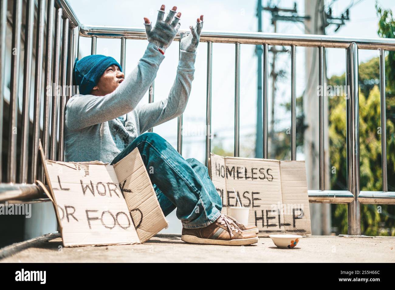 The man sitting begging on an overpass with messages homeless people ...