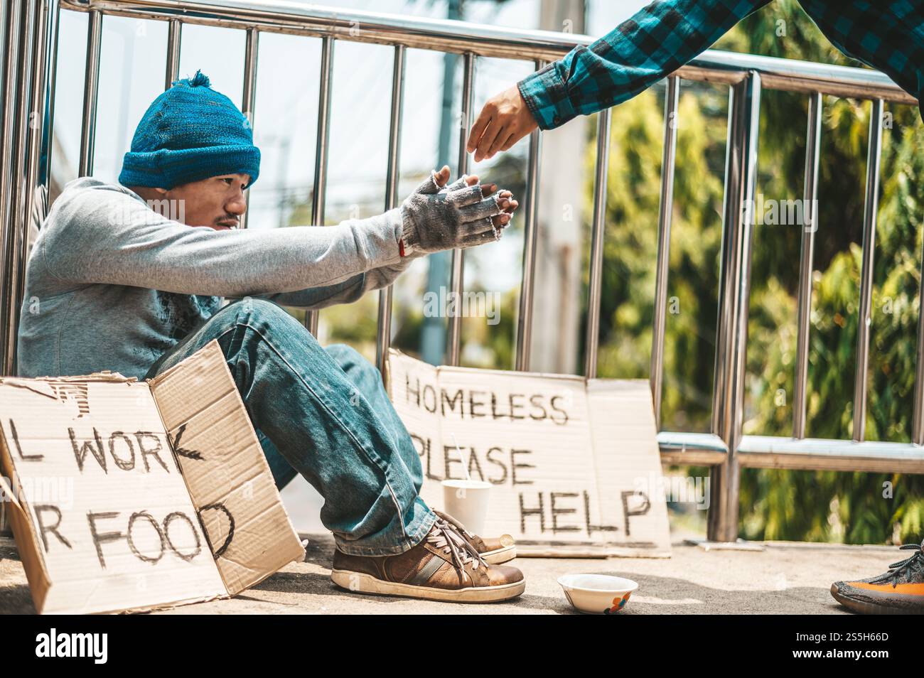 The man sitting begging on an overpass with messages homeless people ...
