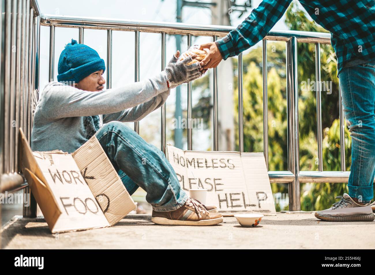 The man sitting begging on an overpass with messages homeless people ...