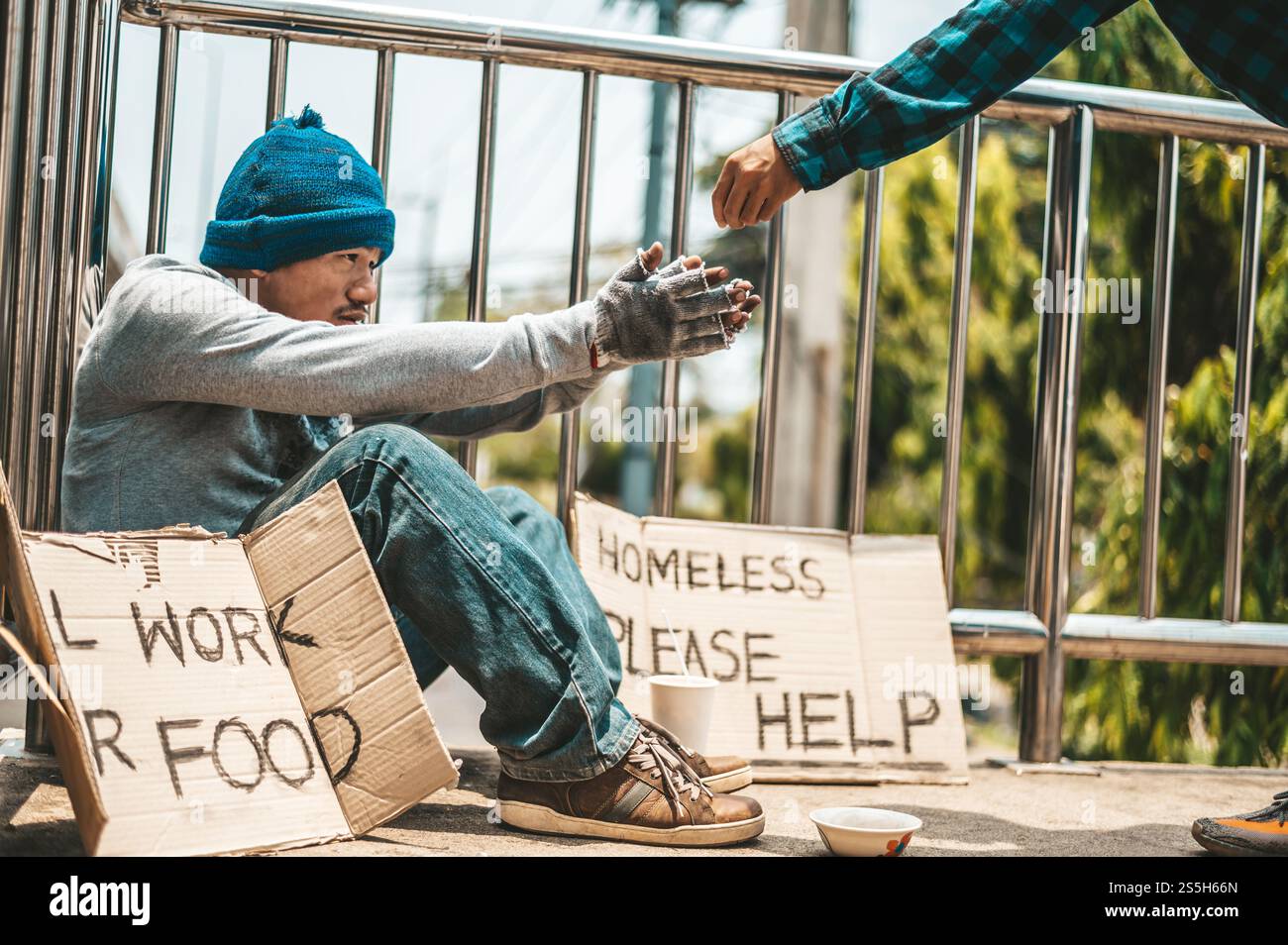 The man sitting begging on an overpass with messages homeless people ...
