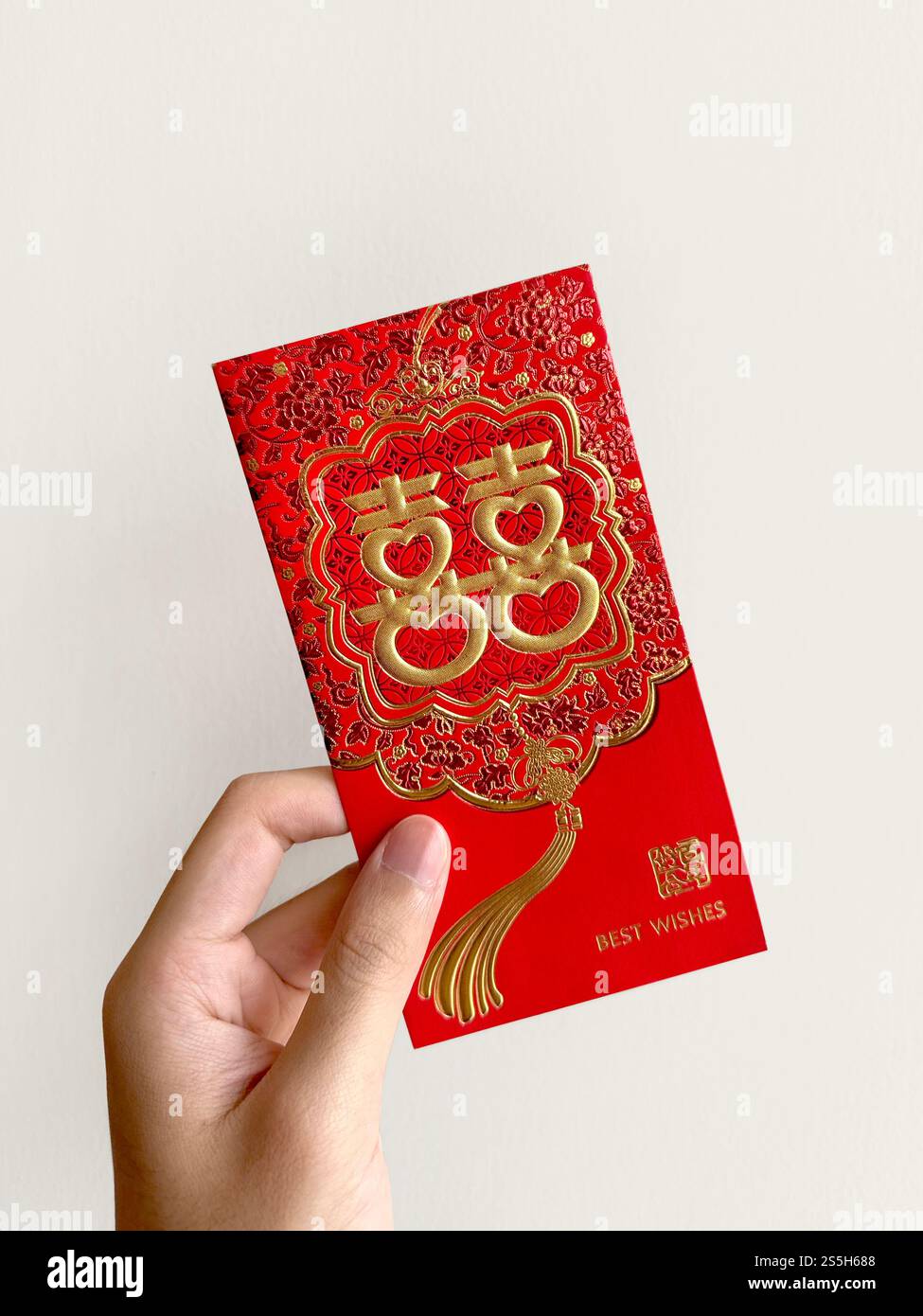 Hand holding Chinese red envelopes, also known as hongbao or angpao ...