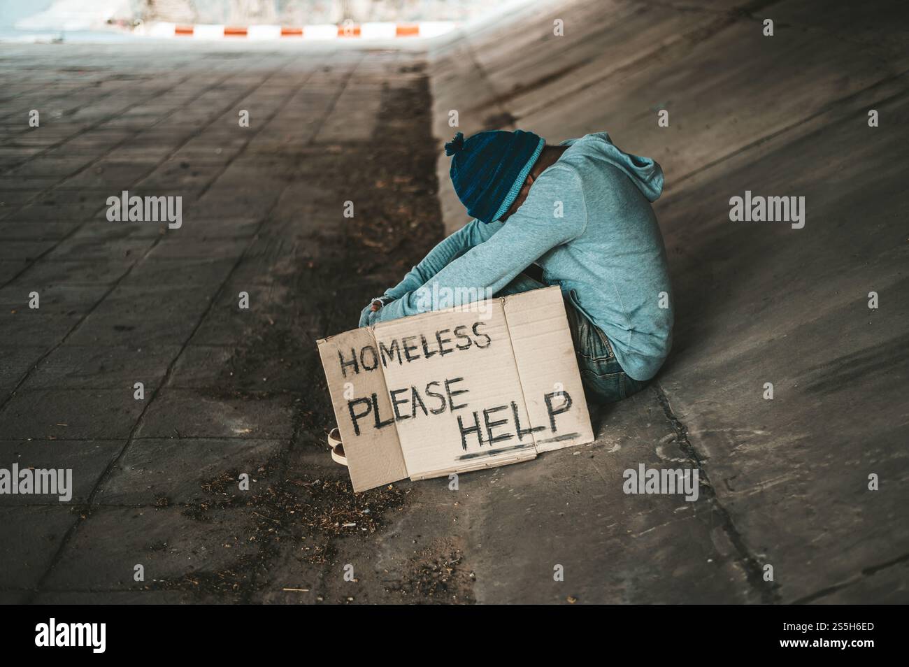 The beggars sit under the bridge with a homeless message. Please help ...