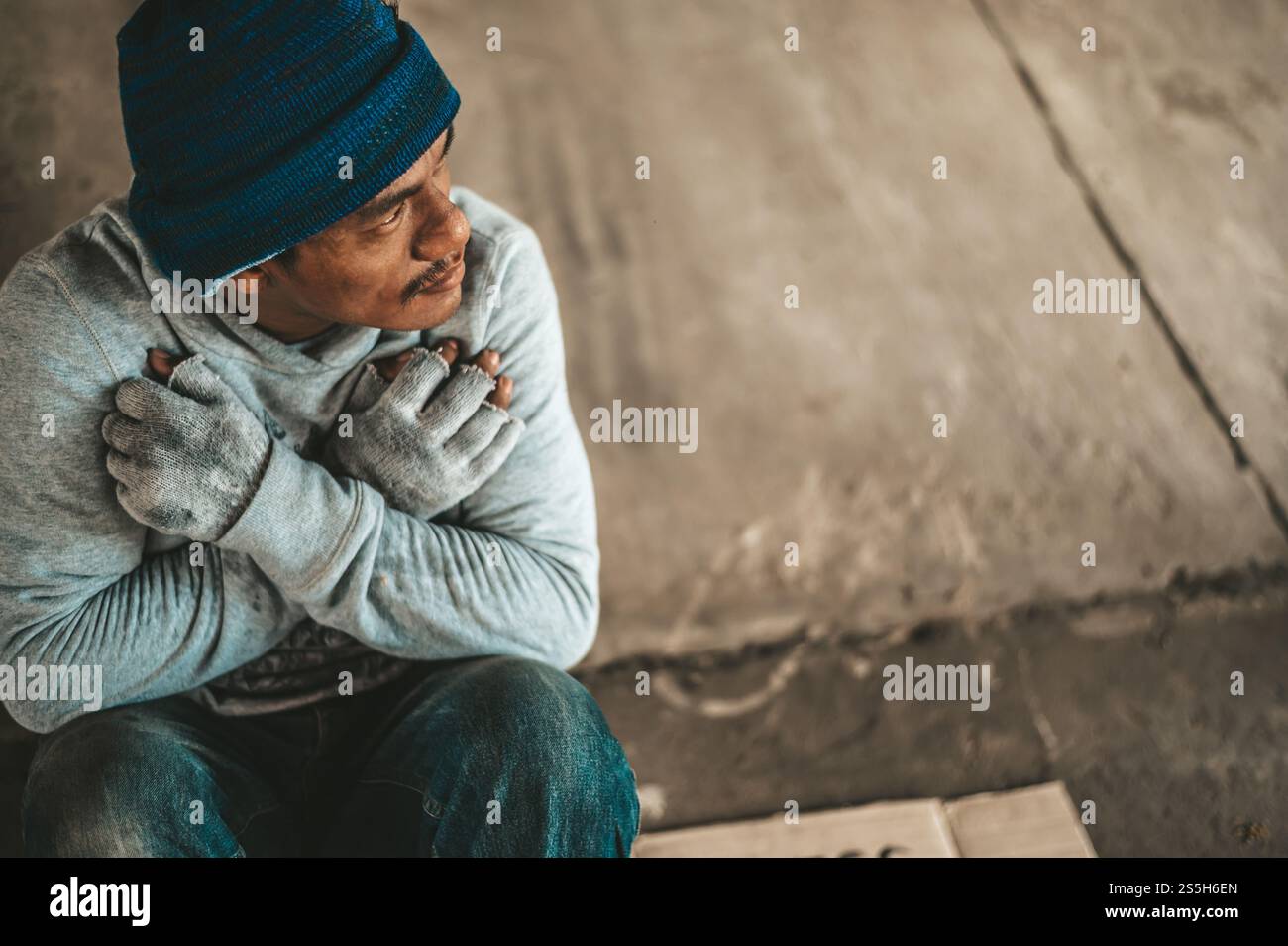 The beggars sit under the bridge with a homeless message. Please help ...