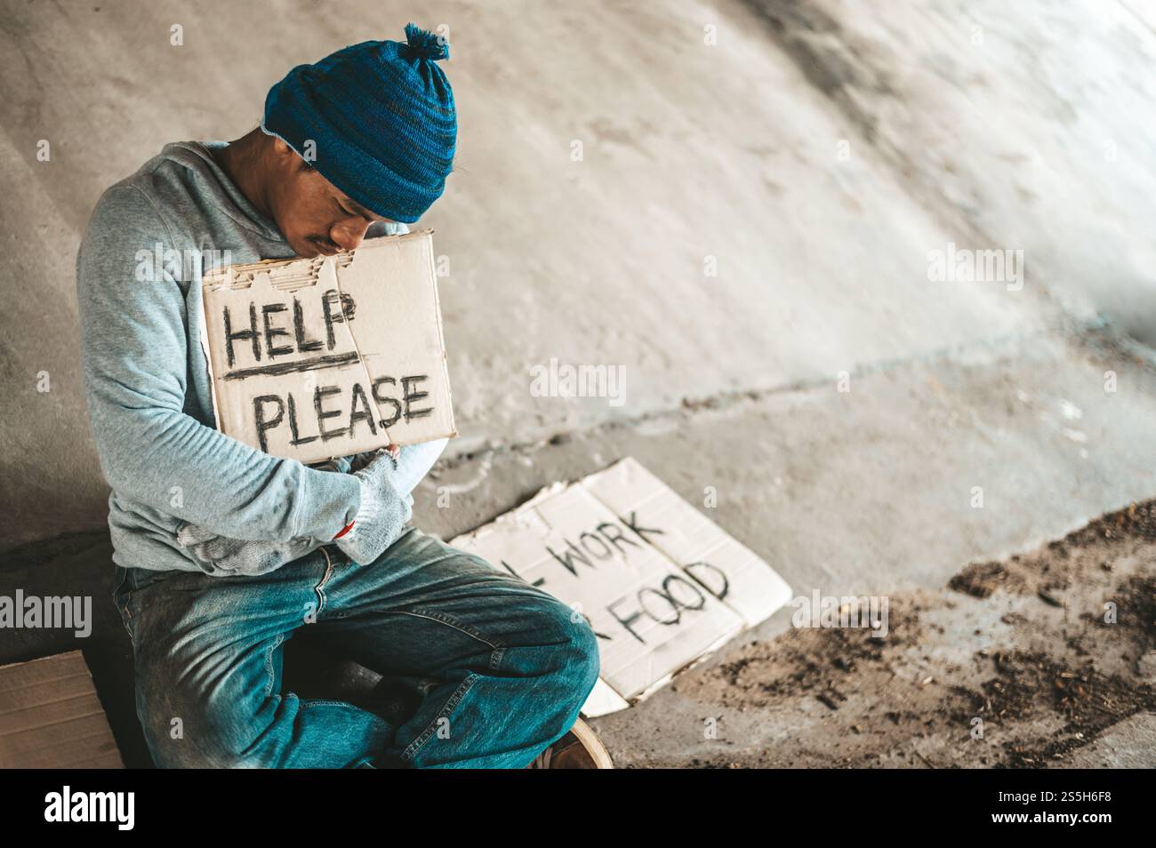 Beggar sitting under the bridge with a sign, help please Stock Photo ...