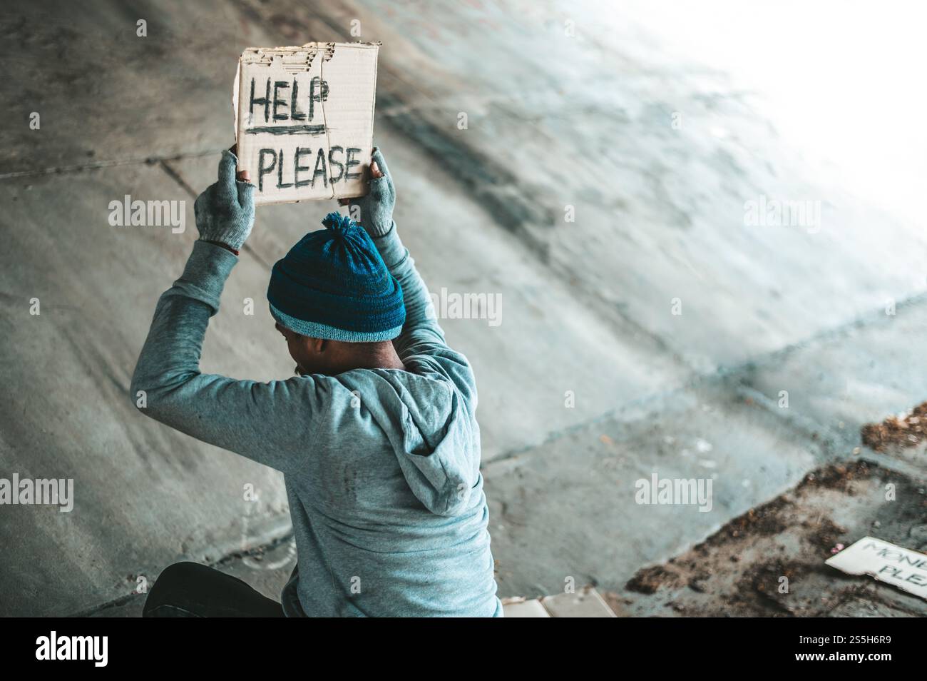 Beggar sitting under the bridge with a sign, help please Stock Photo ...