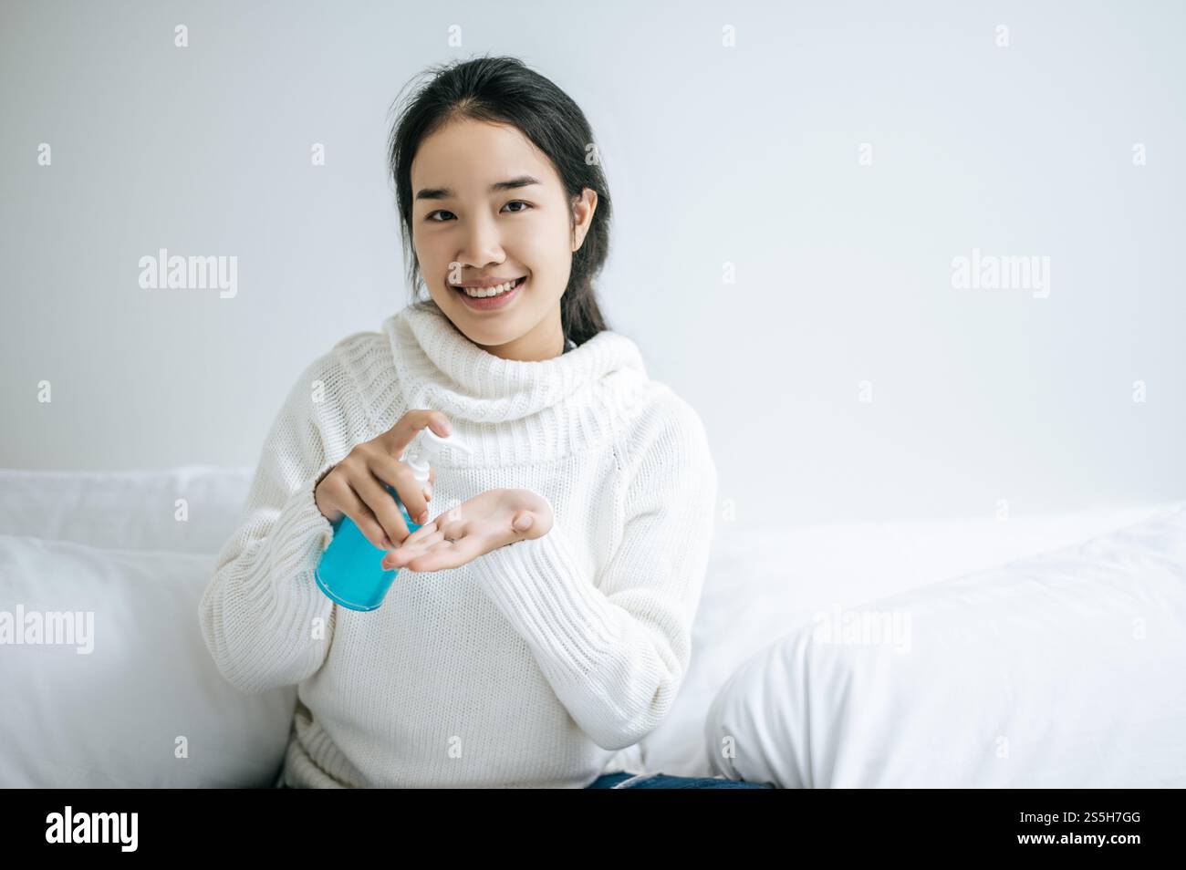 Young women clean their hands with a hand wash gel to prevent germs ... Young women clean their hands with a hand wash gel to prevent germs ...
