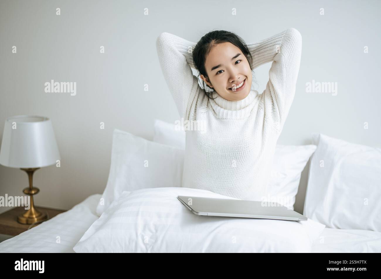 That woman sat on the bed, raised her hand, and put the laptop on the ...