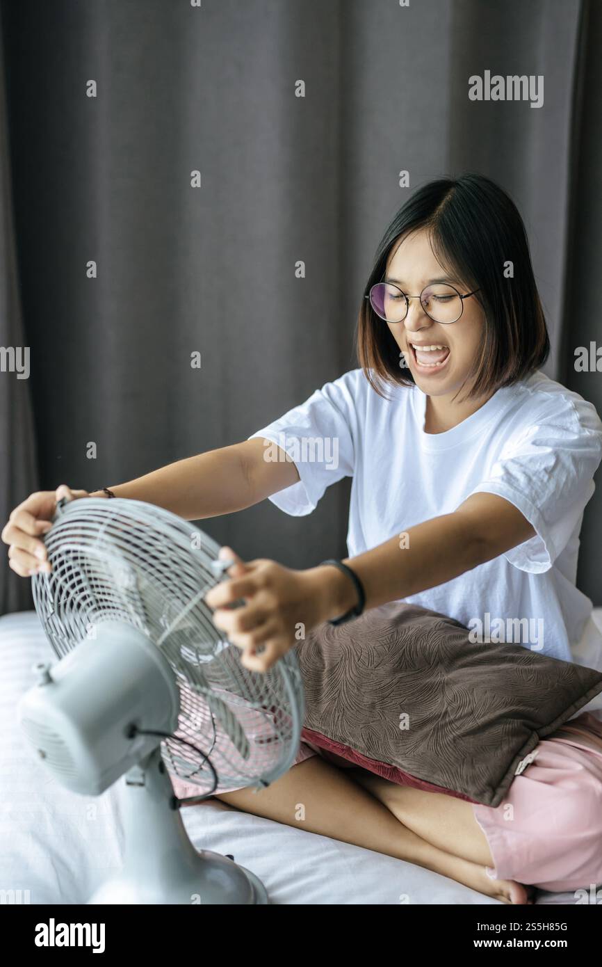Woman wearing a white shirt and a handle to the fan Stock Photo - Alamy