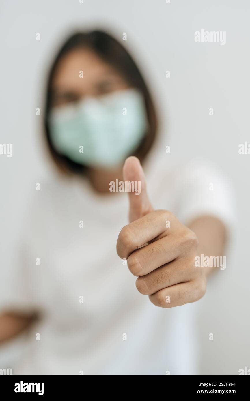 The women wear masks and mark them with their thumbs up Stock Photo - Alamy