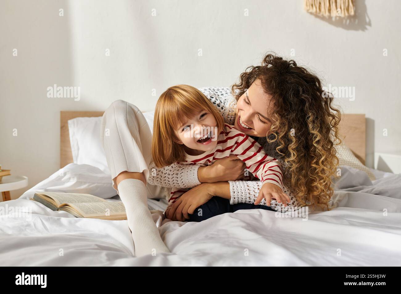 A mother and her daughter relish playful moments together, embracing ...