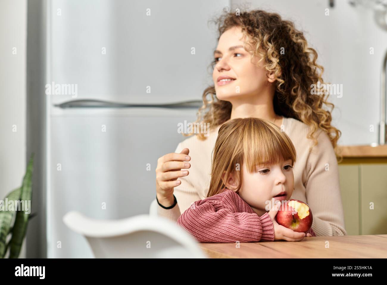 Mother and daughter share a beautiful moment together, embracing the joy of modern parenting ...