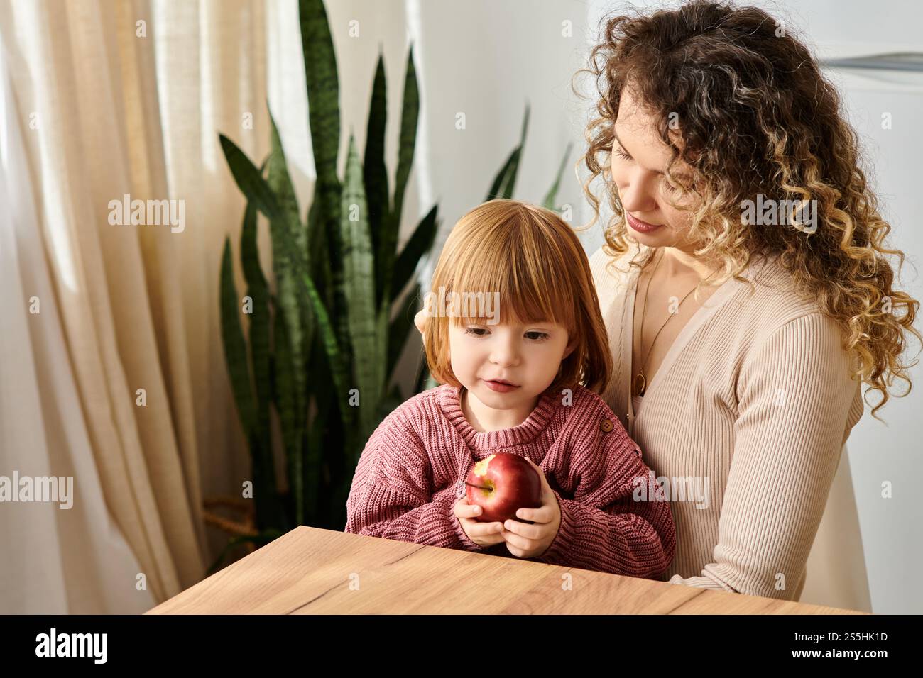 A mother with curly hair enjoys quality time with her daughter ...