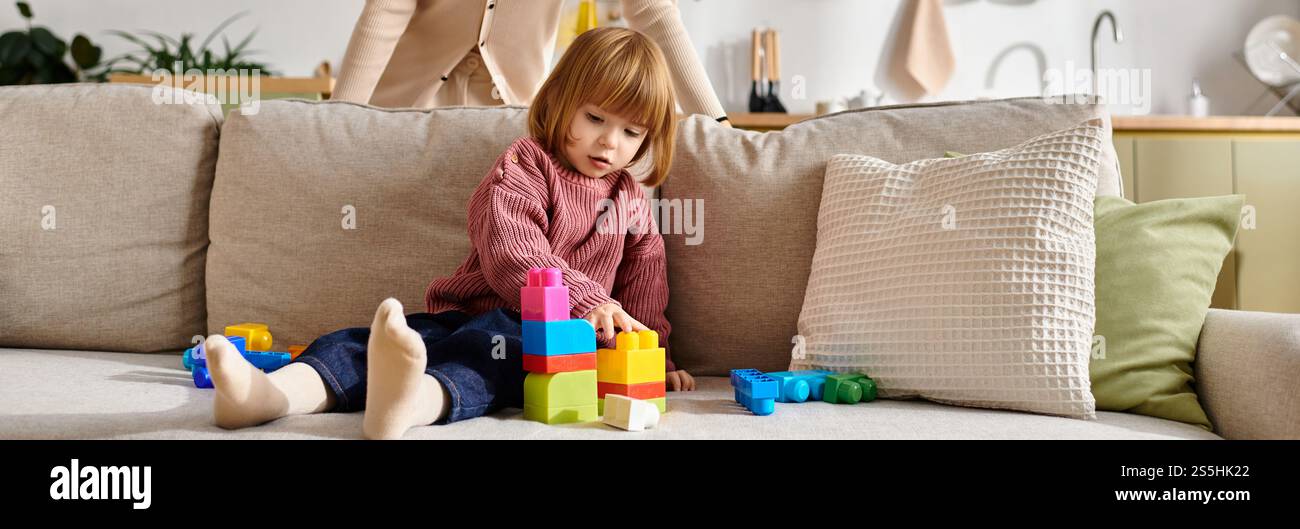 Mother and daughter have a fun-filled day together building colorful blocks on the sofa, banner ...