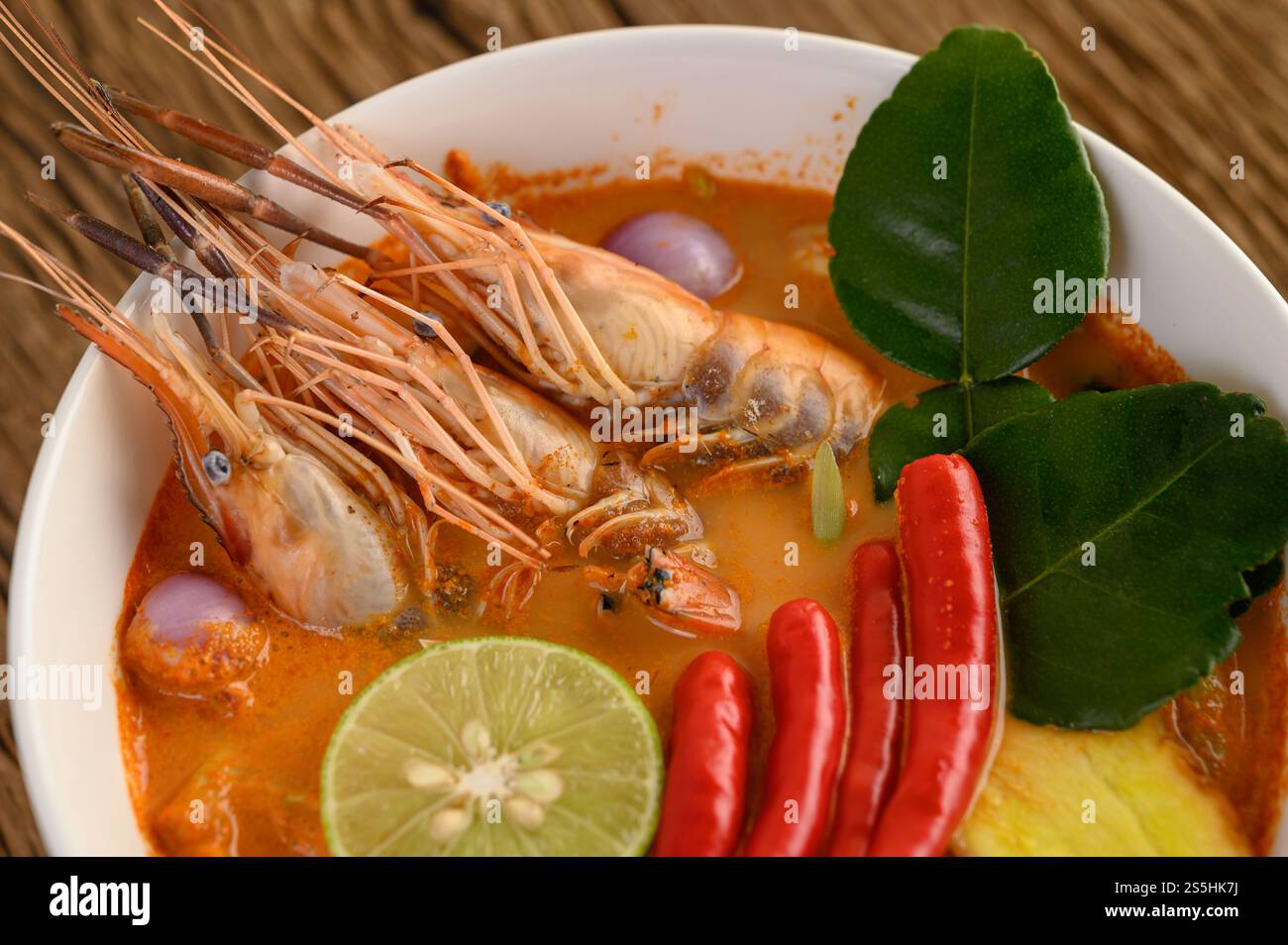 Tom Yum Kung Thai hot spicy soup shrimp with lemon grass,lemon,galangal and chilli on wooden ...