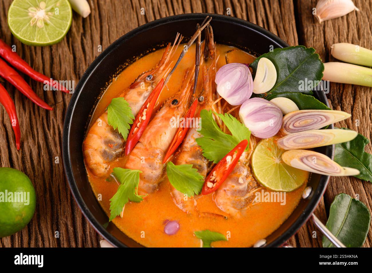 Tom Yum Kung Thai hot spicy soup shrimp with lemon grass,lemon,galangal and chilli on wooden ...