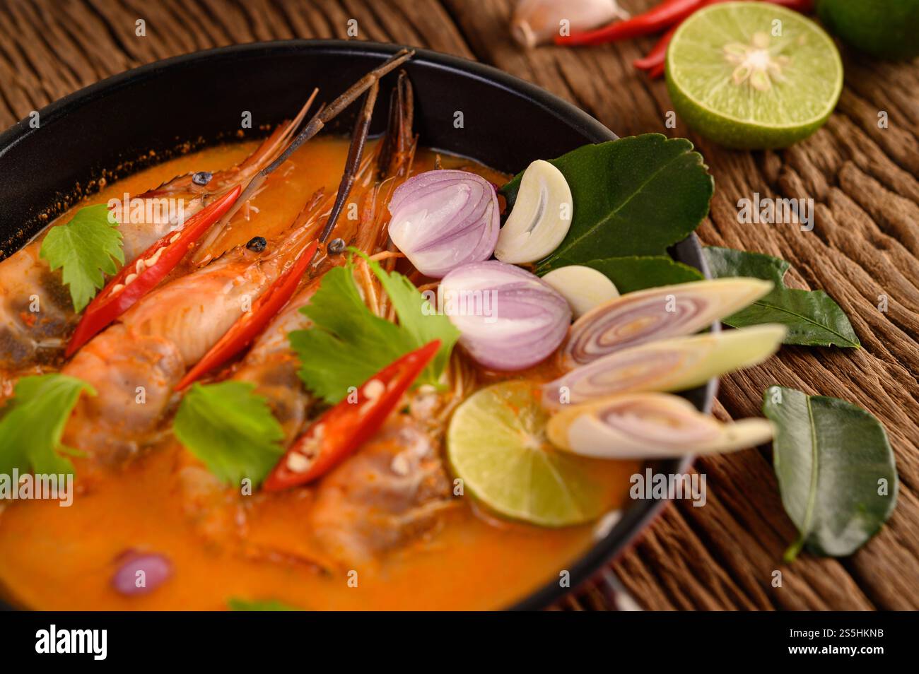 Tom Yum Kung Thai hot spicy soup shrimp with lemon grass,lemon,galangal and chilli on wooden ...