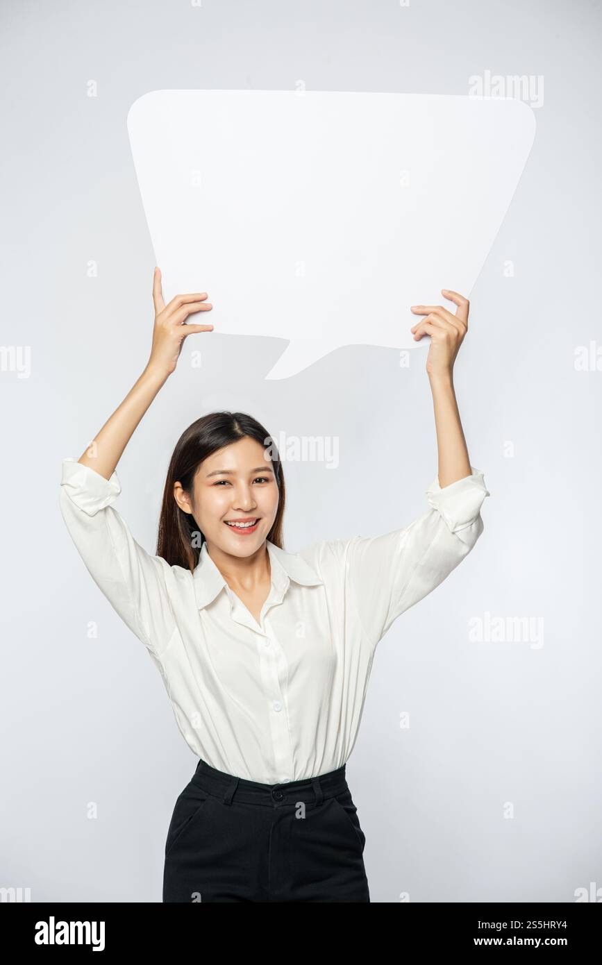 A young woman in a white shirt holding a thought box symbol Stock Photo ...