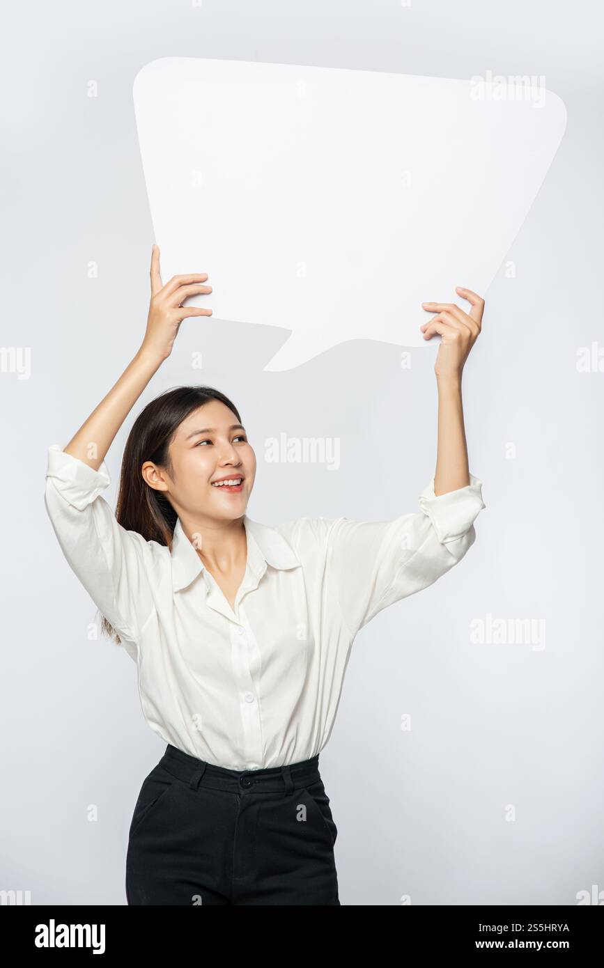 A young woman in a white shirt holding a thought box symbol Stock Photo ...