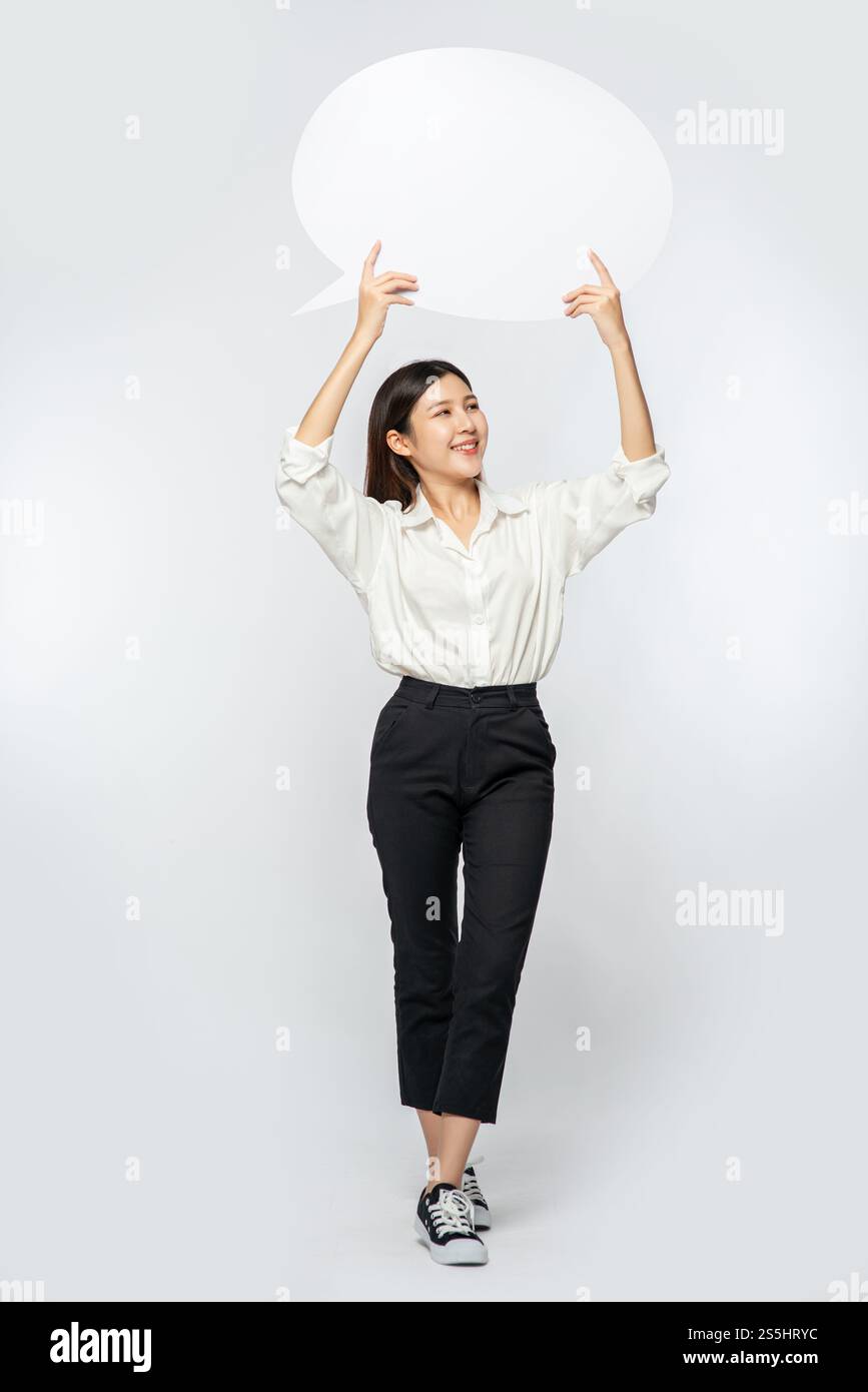 A young woman in a white shirt holding a thought box symbol Stock Photo ...