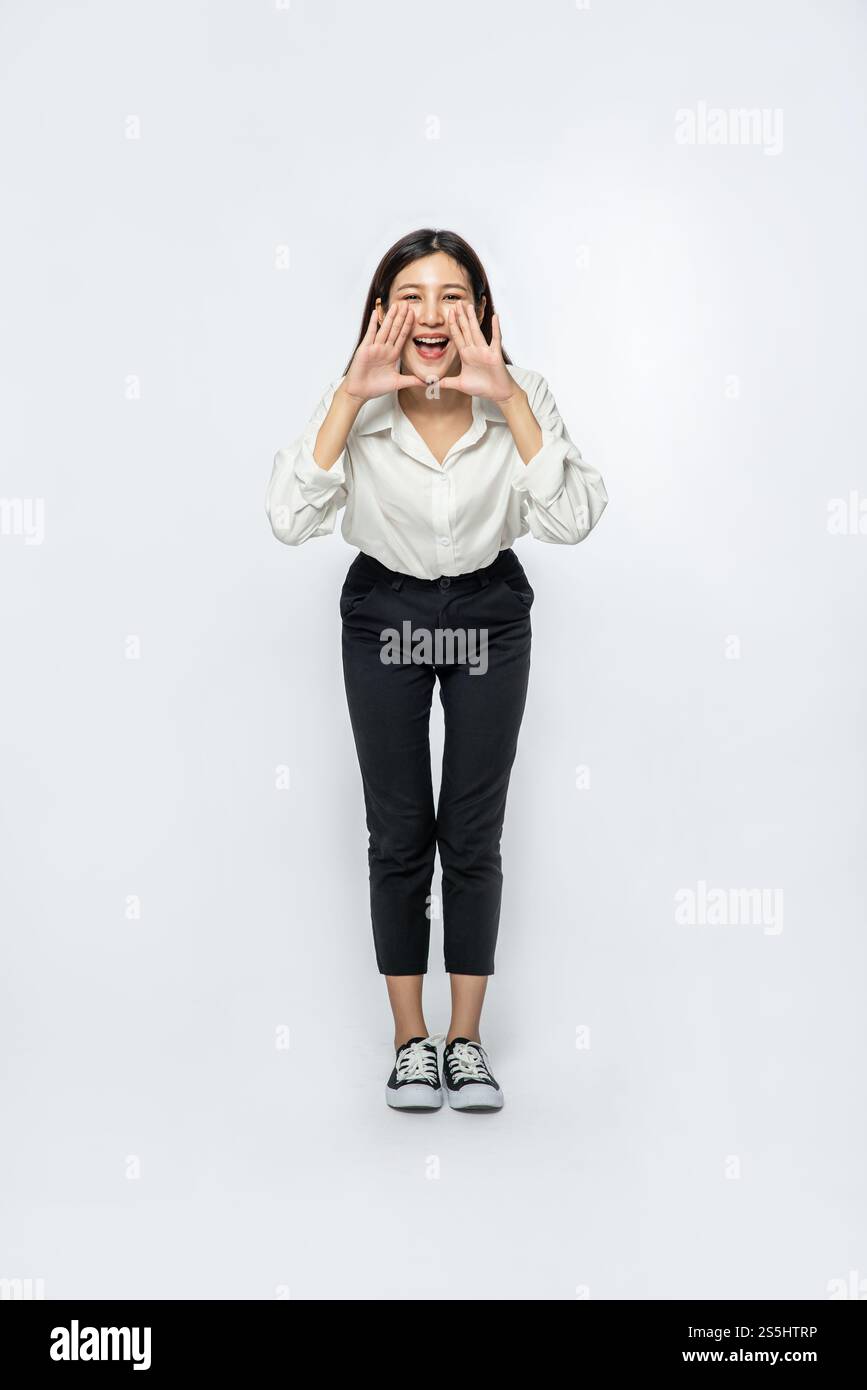 The woman wore a white shirt and black trousers and make a hand shout ...