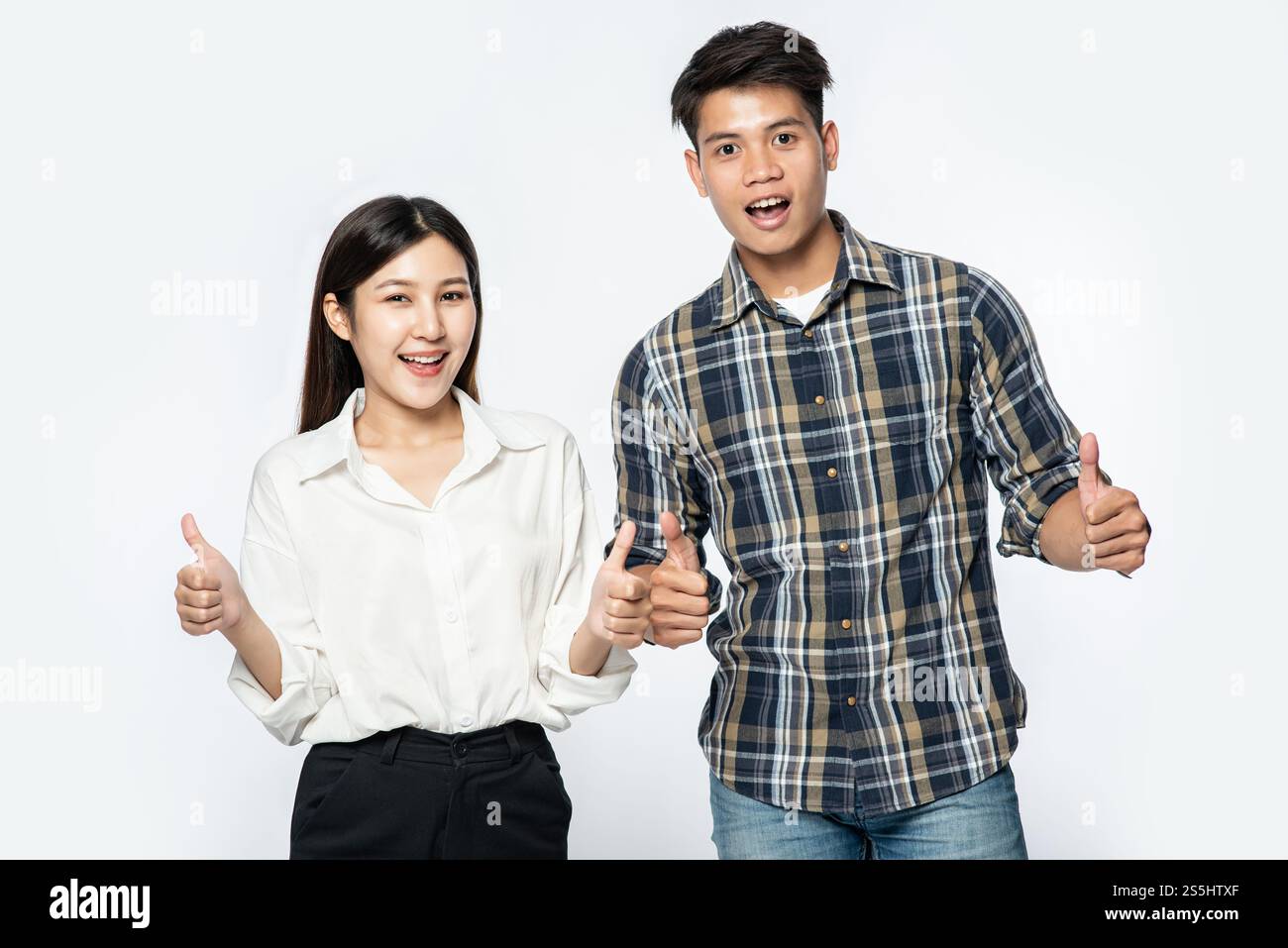 Men and women wearing shirts and making hand signs raise their thumbs ...