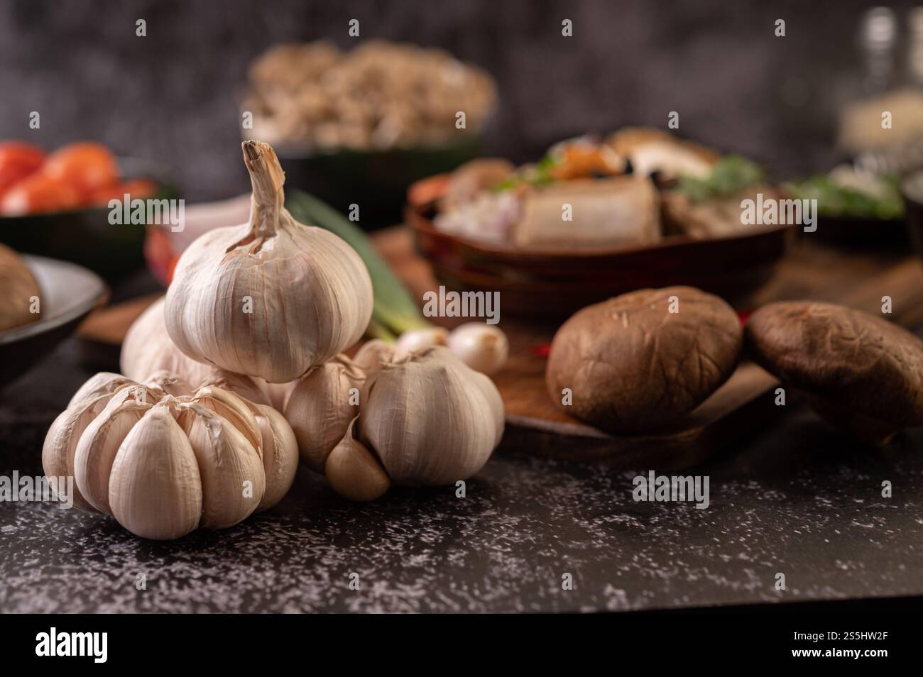 Garlic and shiitake mushrooms are placed on a black cement floor Stock ...