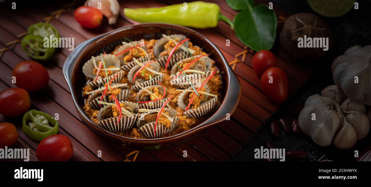 Cockles sauteed in curry powder with bell peppers and tomatoes Stock ...