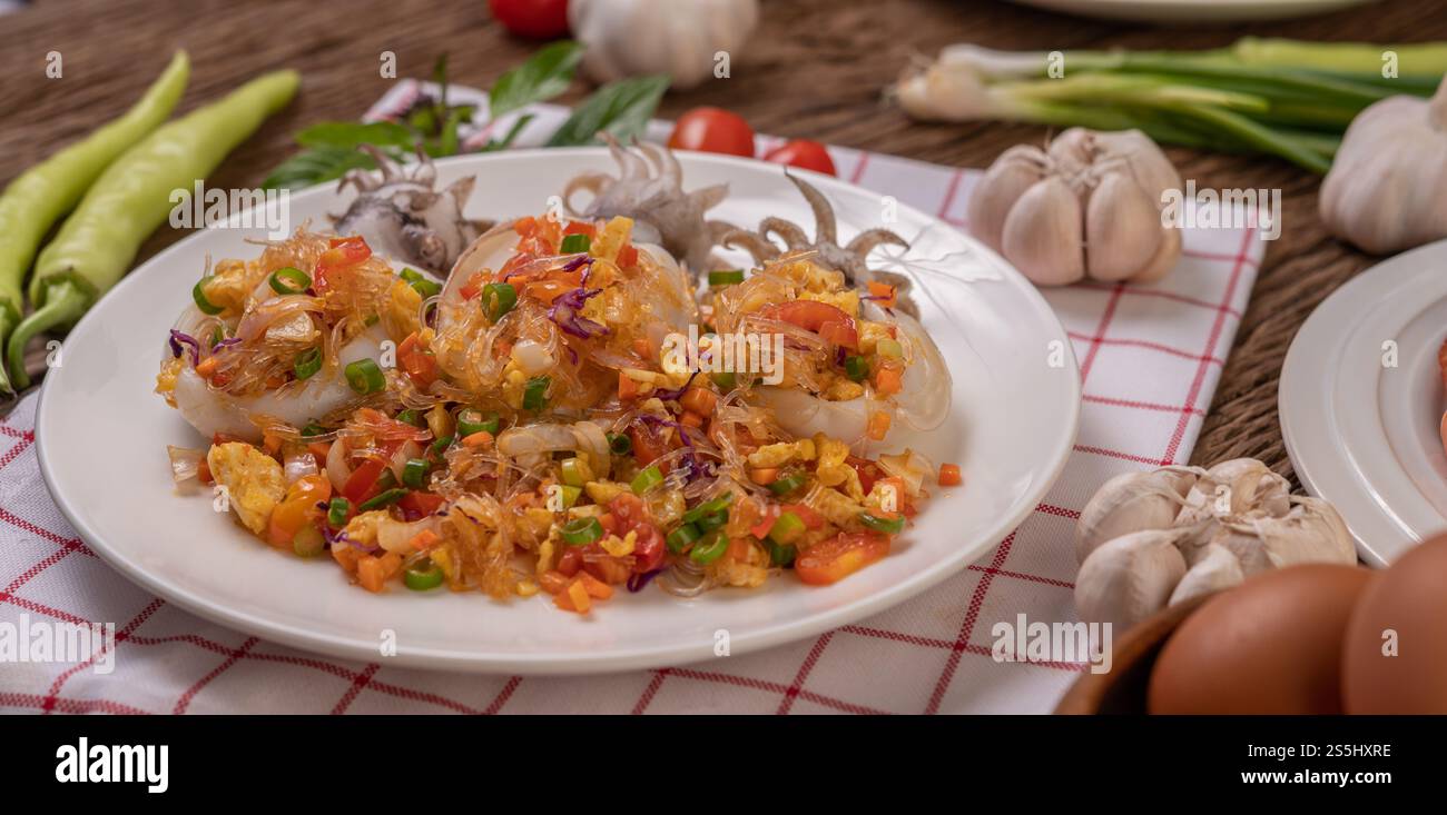 Stir fried glass noodles with squid in a plate on red white cloth Stock ...